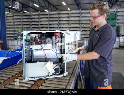 E-waste. Workplace Road2work, A mechanic disassembles a washing machine ...