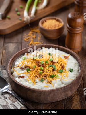 Creamy potato soup with bacon pieces, shredded cheddar cheese and ...