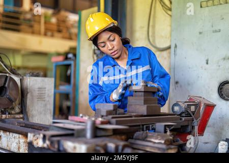 Woman worker in uniform operating machine at factory concentrate on ...