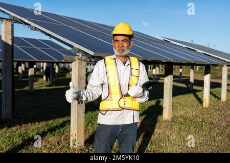 Maintenance engineer at greenery Solar farm at work hold tablet ...