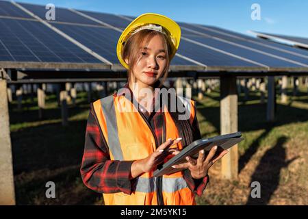 Maintenance engineer at greenery Solar farm at work hold tablet ...