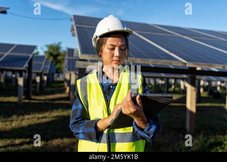 Maintenance engineer at greenery Solar farm at work hold tablet ...