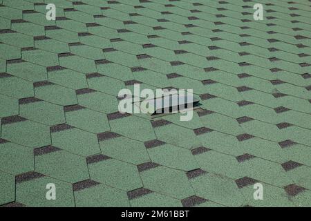 Roofing made of green soft bitumen tiles on a hipped roof of a house ...