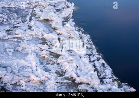 Ice-bound river and floating floe on a sunny frosty winter day. The ...