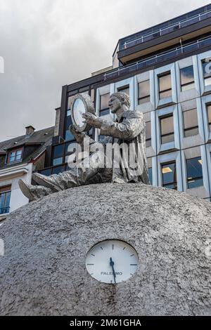 Statue of Man holding clock on top of a ball in Dijon, France Stock ...