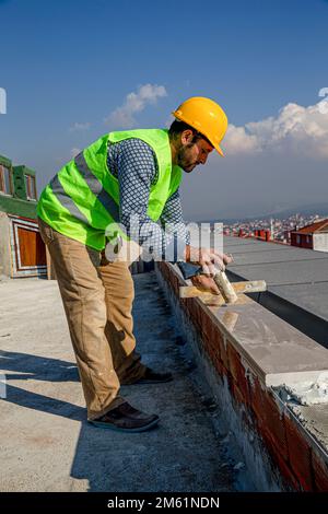 The builder is hitting the marble with a hammer and leveling it with a ...