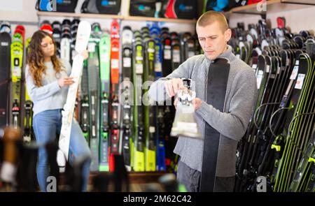 Man choosing new skis in store of sports Stock Photo - Alamy