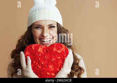 Hello winter. happy trendy female in beige sweater, mittens and hat ...