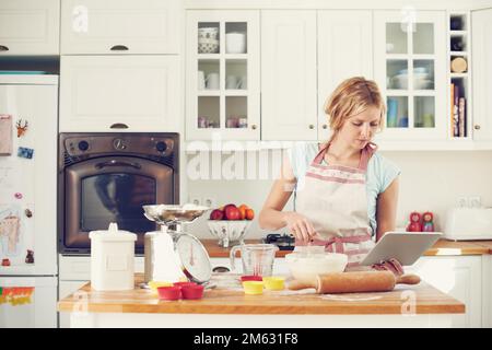 Keep calm and bake on. a young woman baking in her kitchen Stock Photo ...