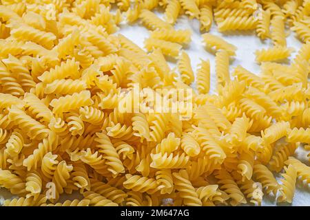 Stack of spiral macaroni on blue background food and drink concept ...