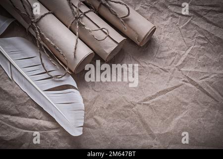 Stack of vintage paper scrolls quill on crumpled wrapping sheet Stock ...