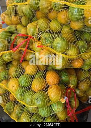 Yellow mesh bags of oranges pilled up on pallet Stock Photo - Alamy