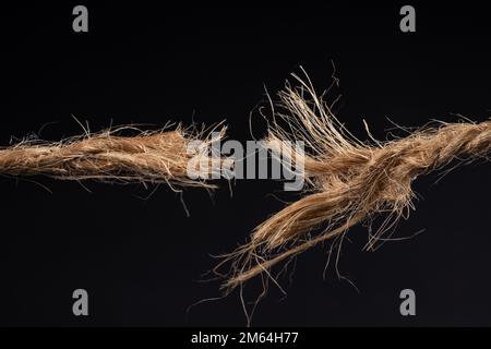 Breaking rope isolated on black background Stock Photo - Alamy
