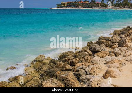 View of big rocks protecting sandy coastline. Turquoise water of ...