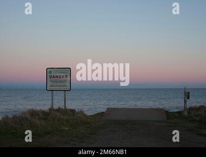 Warm peach link yellow sky over blue sea at sunset at Spurn Point East ...