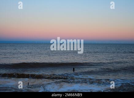 Warm peach link yellow sky over blue sea at sunset at Spurn Point East ...