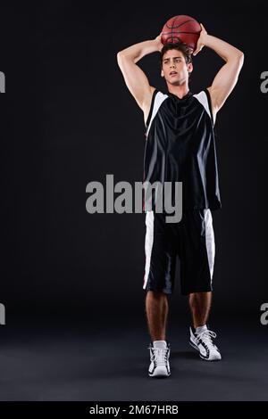 Time to shoot some hoops. Studio shot of a young basketball player ...