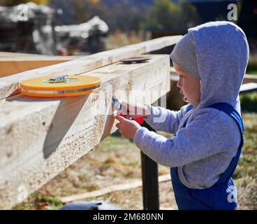 Boy toddler playing as builder on construction site. Child carpenter in ...