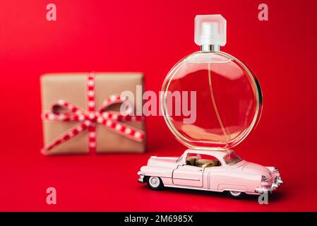 A gift for Valentine's Day. Perfume and a box with a gold chain on a ...