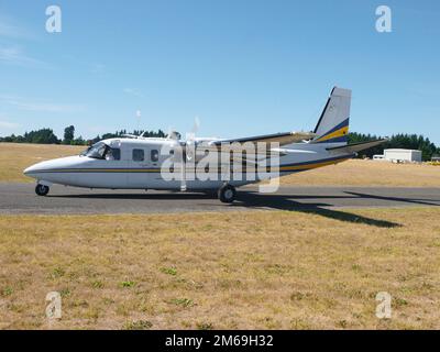 A small twin engine commuter plane flies into the beautiful orange ...