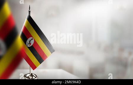 Small flags of the Uganda on an abstract blurry background Stock Photo ...