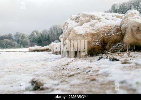 lying pieces of ice on the seashore, icicles of different sizes ...