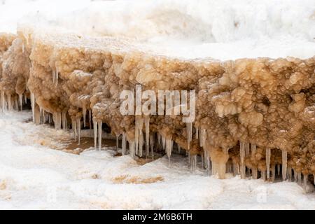 lying pieces of ice on the seashore, icicles of different sizes ...