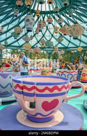 A beautiful shot of people enjoying the Mad Hatter's Tea Cups' carousel ...
