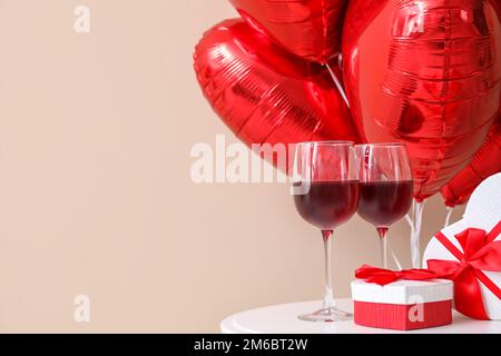 Table with glasses of wine, gifts and balloons for Valentine's Day near ...