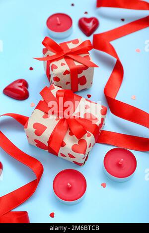 Gifts with candies, ribbon, candles and hearts on blue background ...