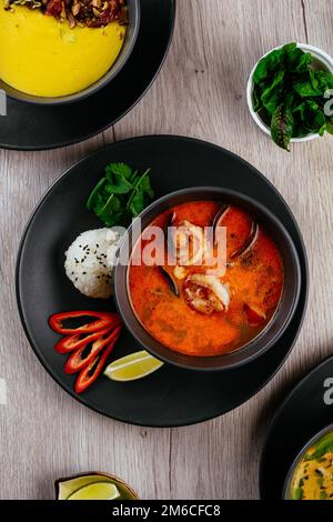 A bowl of delicious spicy asian shrimp noodle soup with mushroom, red ...