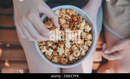 Friends eating popcorn on the street. Close-up of hands Stock Photo - Alamy