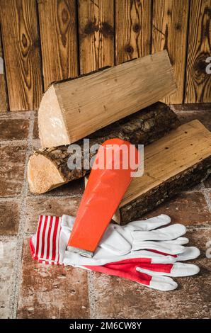 Saw, mittens and firewood, close-up Stock Photo - Alamy