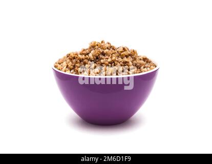Dry buckwheat in purple ceramic bowl isolated on white background ...