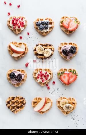 Heart shaped mini waffles with various toppings displayed in rows Stock ...