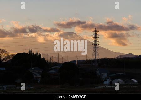 Mount Fuji at sunset behind electricity pylons in rural Kanagawa, Japan ...