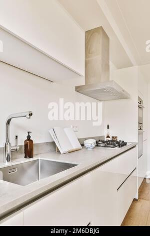Stainless faucet with sink in counter under shining lamps in stylish ...
