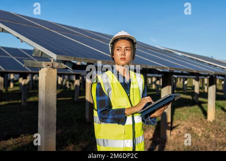 Maintenance engineer at greenery Solar farm at work hold tablet ...