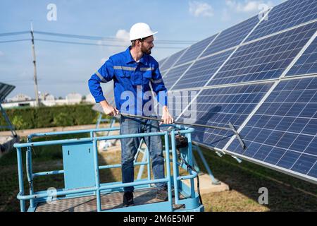 Service engineer use a mop cleaning solar panel for good performance ...