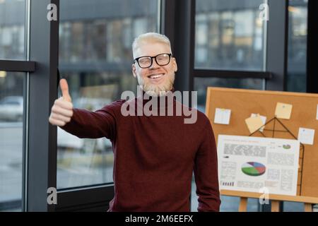 bearded albino businessman in glasses using smartphone near laptop in ...