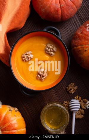 Pumpkin with walnuts and honey in a bowl on a napkin, mint and fork on ...