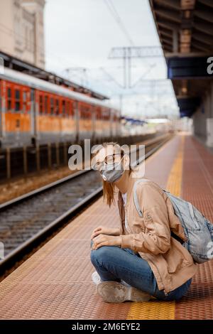woman sitting near the railway Stock Photo - Alamy