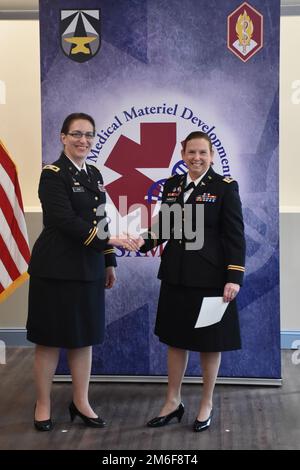 Army Col. Gina E. Adam, USAMMDA commander, presents Mark Brown with a ...