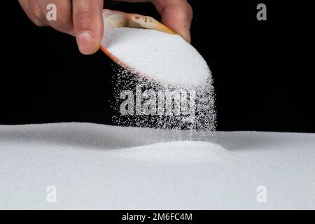 sand pouring out of sea shells on black background Stock Photo - Alamy