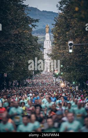 Many runners in the Bilbao Night Marathon, running in the streets of ...