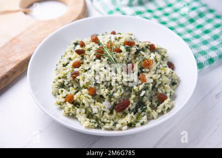 Risotto with spinach and raisins. Risotto is a northern Italian rice ...