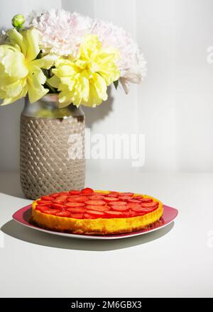 A fresh homemade strawberry cheesecake against a light background Stock ...