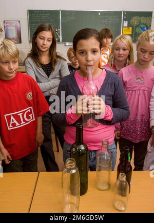 By blowing or tapping against bottles filled with water, the air in the ...