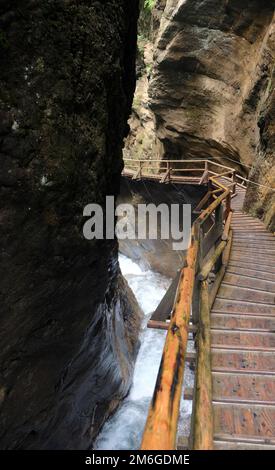 Wooden walkpath as bridge over cascading waterfall Stock Photo - Alamy