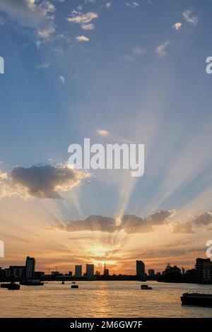 Golden rays of sun shine out from behind the Shard in the distance over ...
